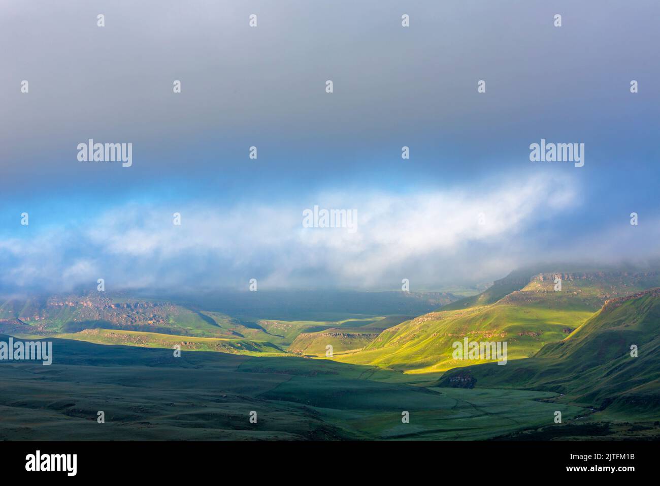 First light of the day break through the clouds Drakensberg South ...