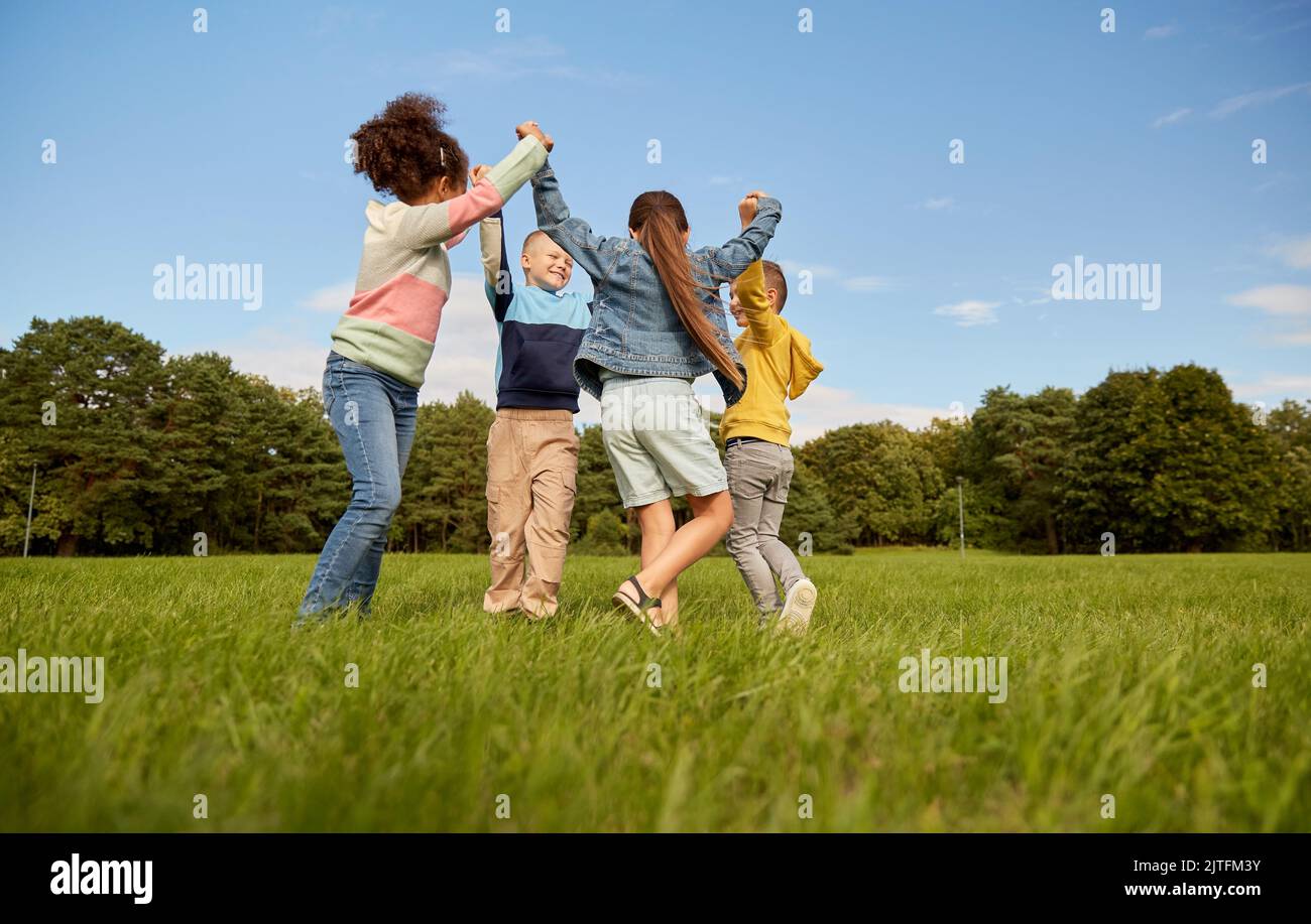 happy children playing round dance at park Stock Photo - Alamy