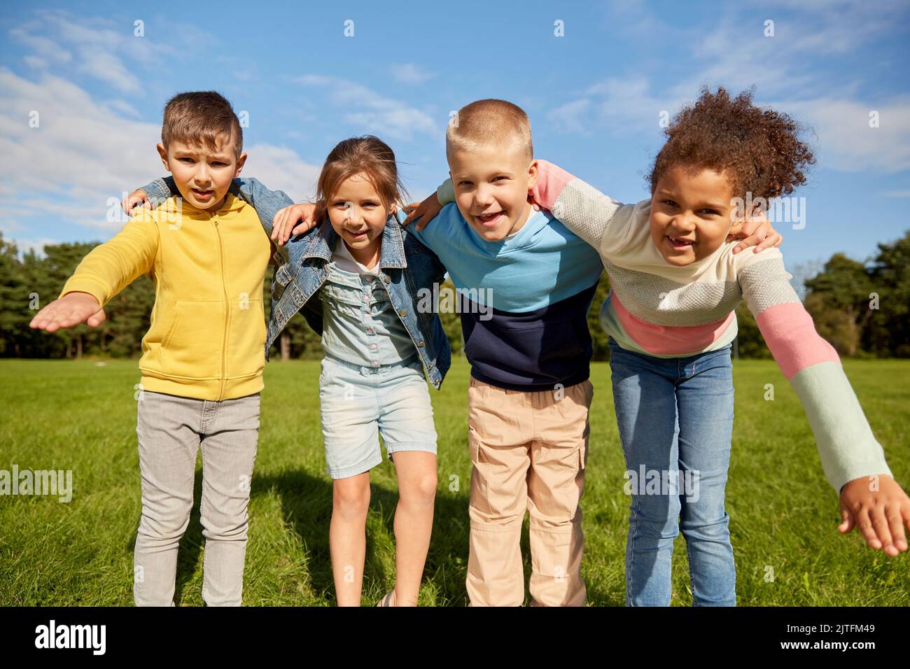 group of happy children hugging at park Stock Photo - Alamy