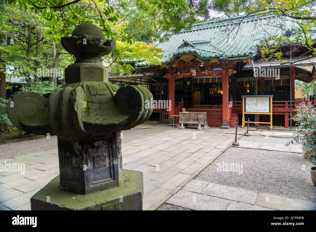A stone lantern in the honden with the haiden worship hall at the ...