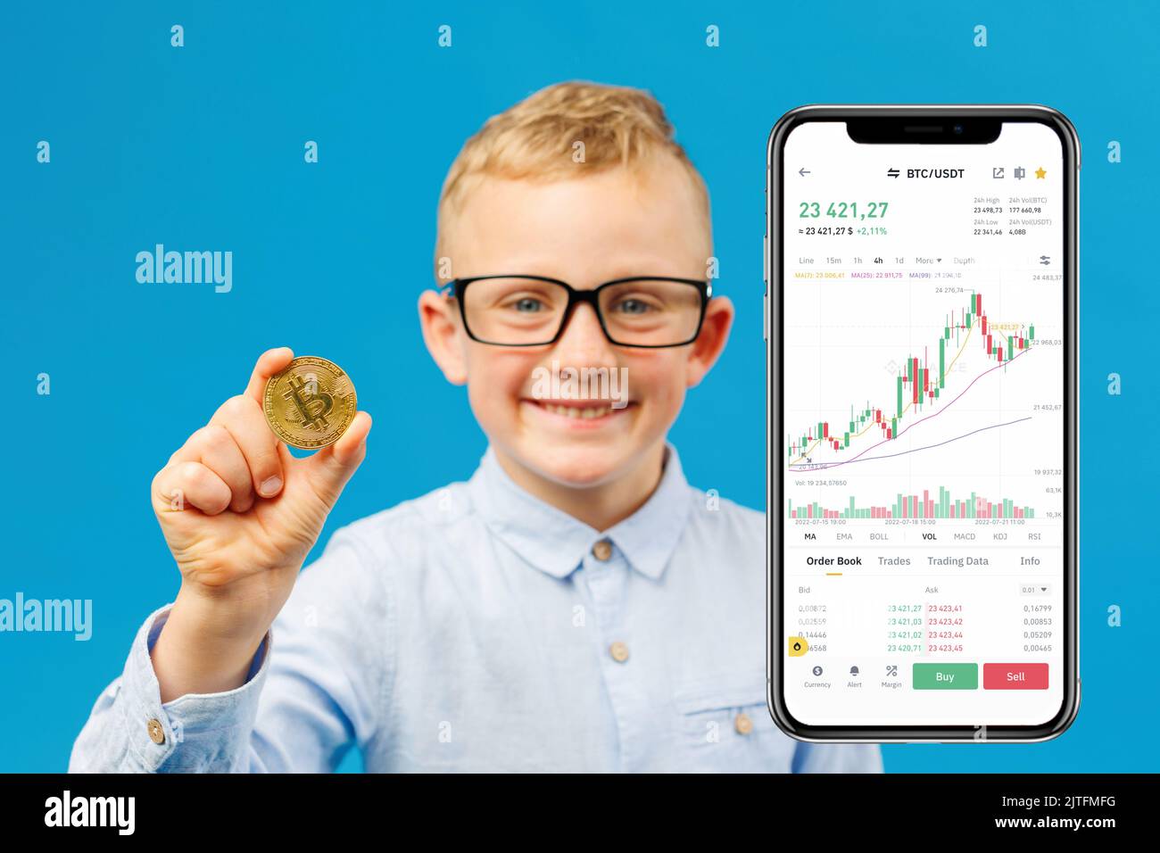 Happy cute business boy is having fun and holding bitcoin in hand on ...