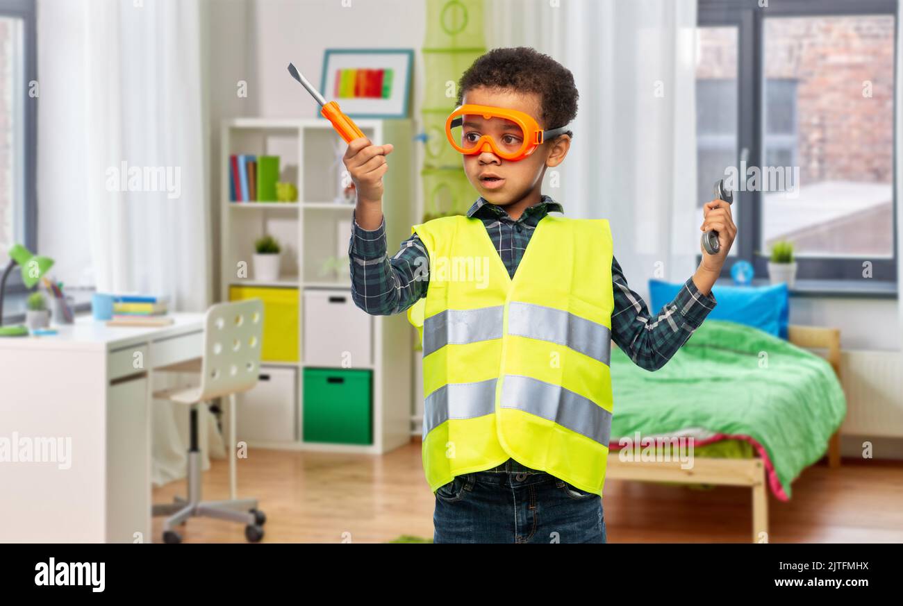little boy in safety vest with screwdriver at home Stock Photo - Alamy