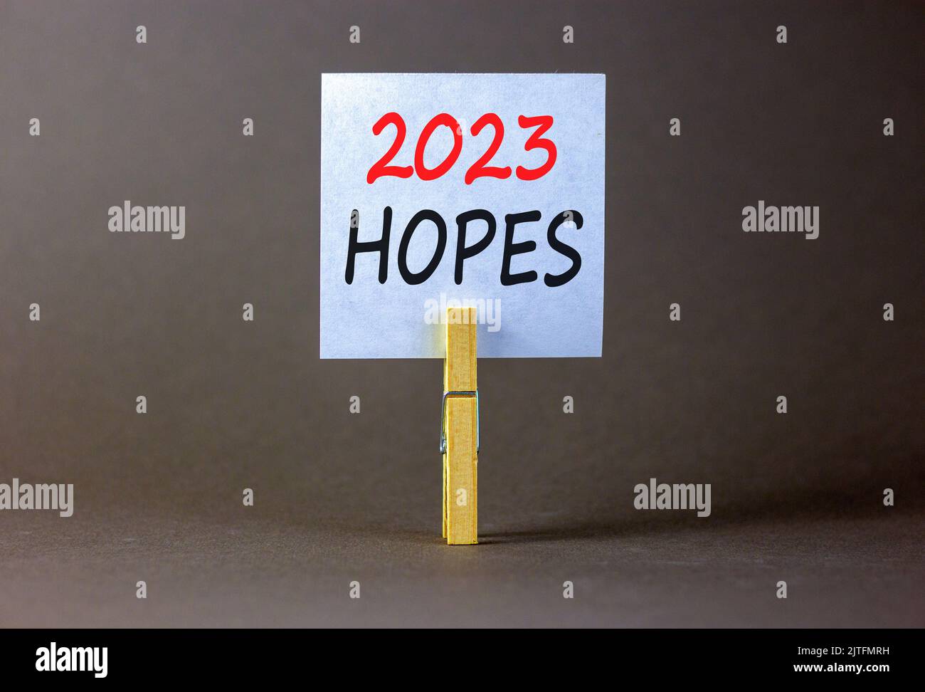 2023 Hopes symbol. White paper with words 2023 Hopes, clip on wooden ...