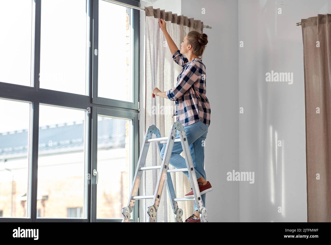 Woman on ladder hi-res stock photography and images - Alamy