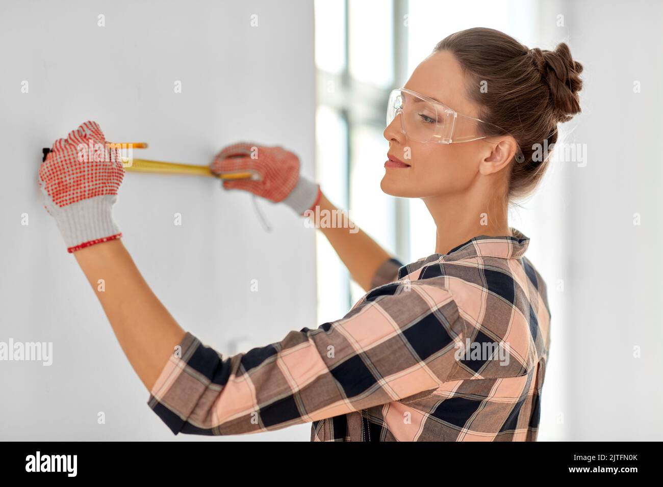 woman with ruler and pencil measuring wall at home Stock Photo - Alamy