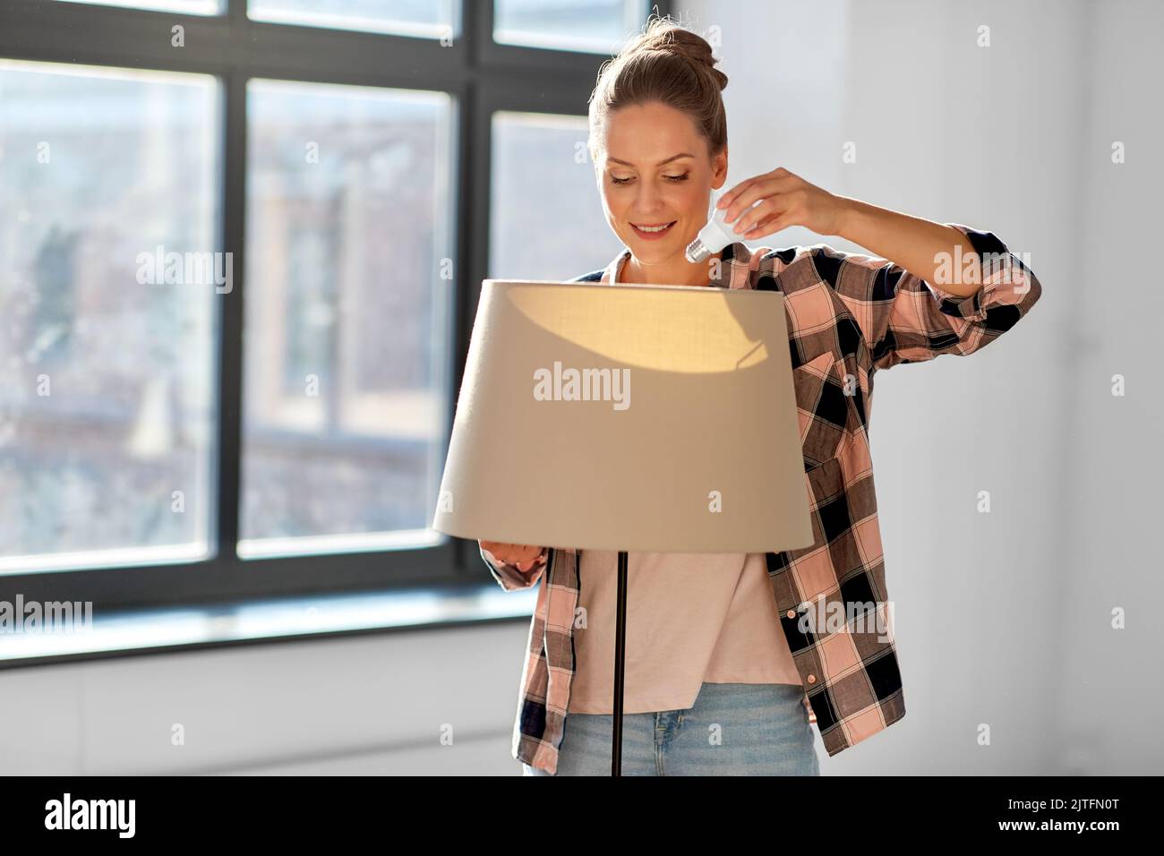 woman changing light bulb at new home Stock Photo - Alamy