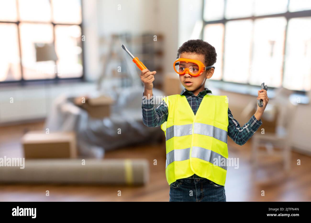 little boy in safety vest with screwdriver at home Stock Photo - Alamy