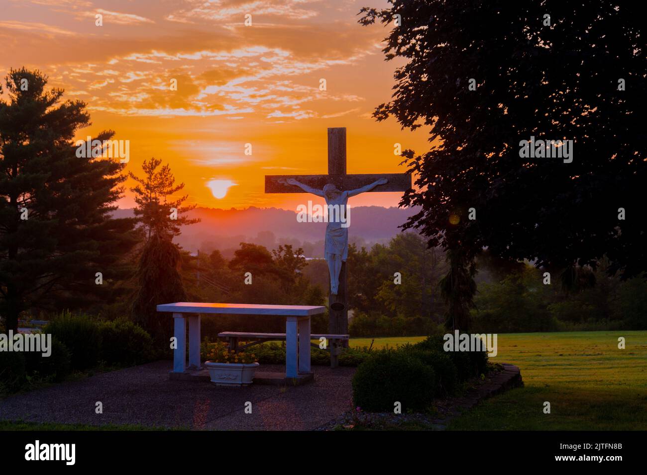 Sunrise over cross on a misty morning Stock Photo - Alamy