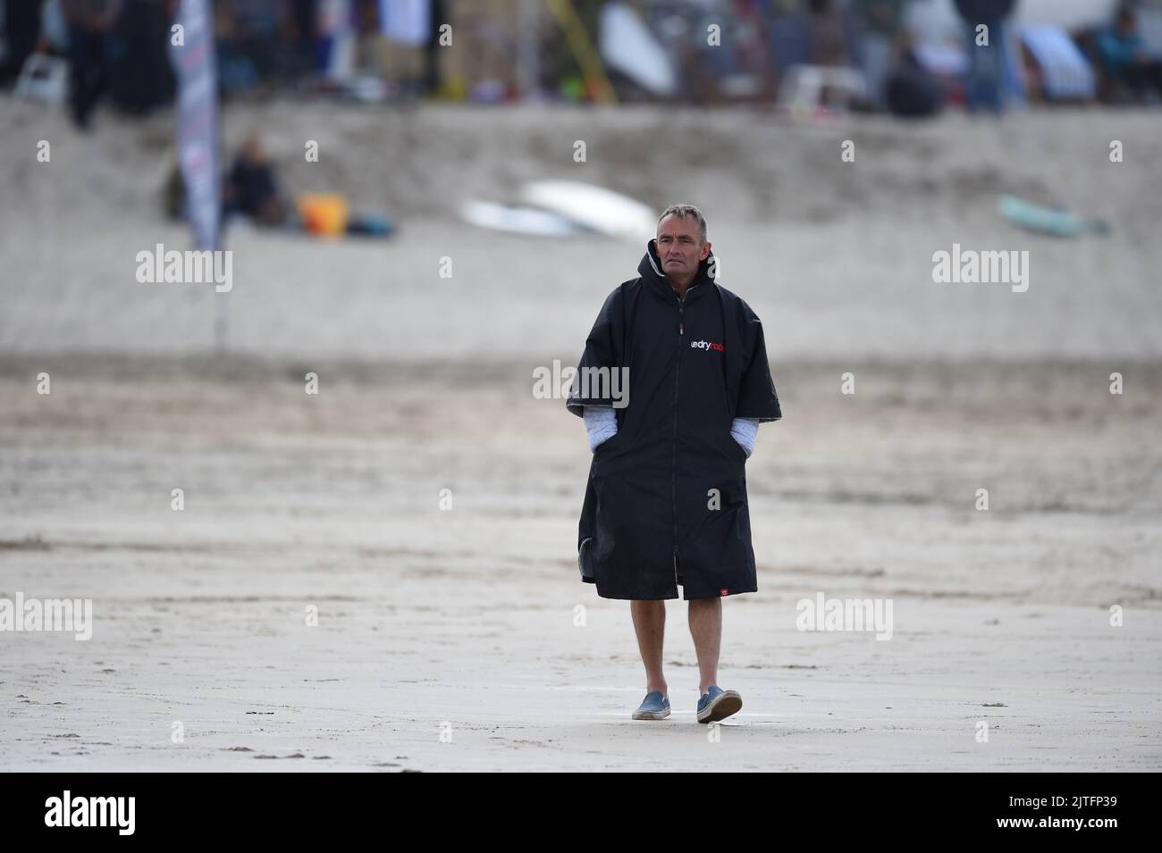 Man walking on beach in super dry robe Stock Photo - Alamy
