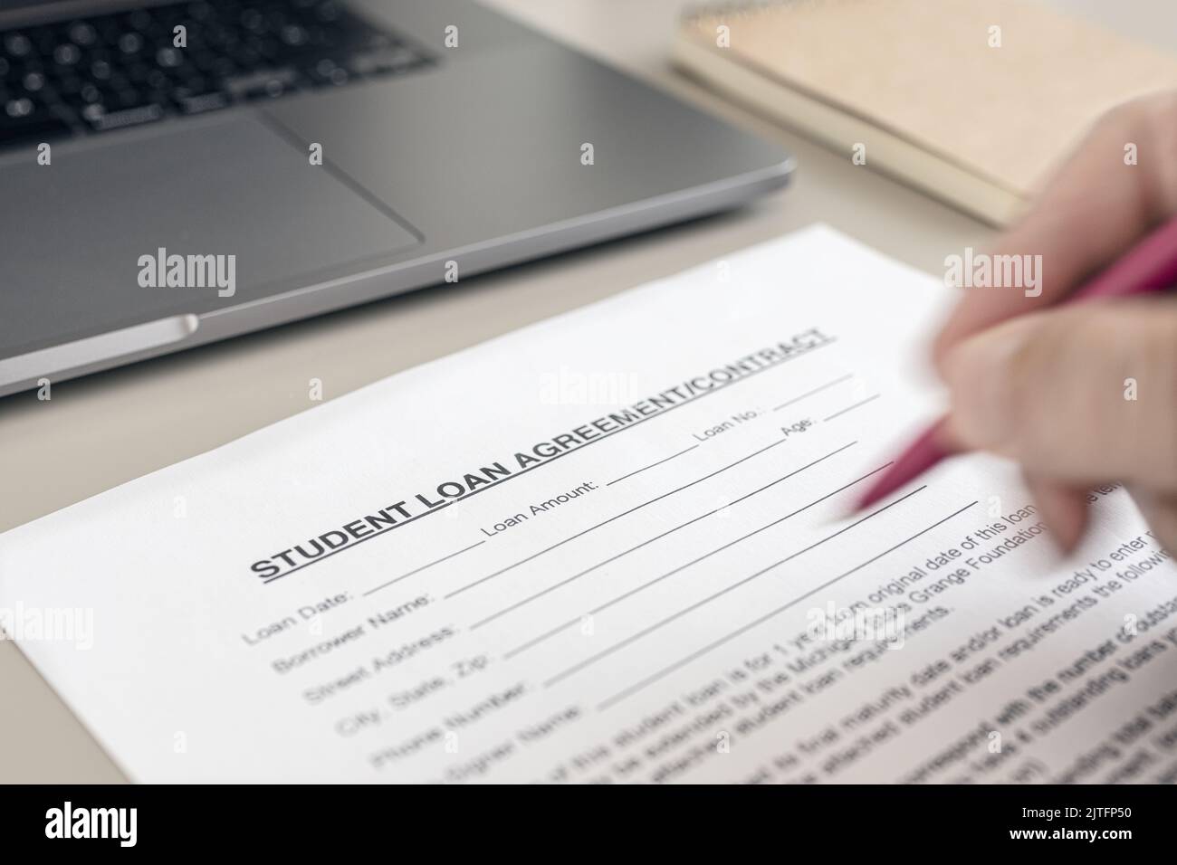 Human hand filling a Student Loan form on the desk. Education cost ...