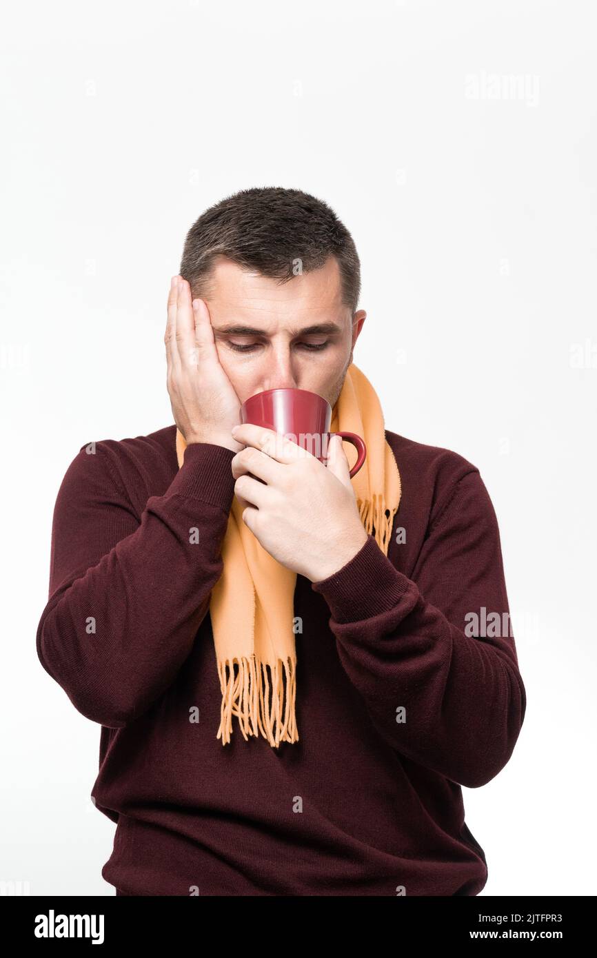 A handsome man touches his mouth with his hand with a pained expression ...