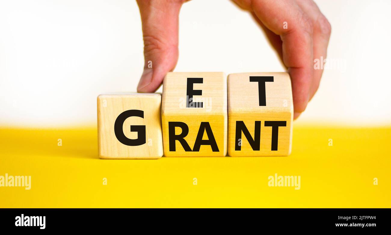 Get grant symbol. Businessman turns wooden cubes with concept words Get ...