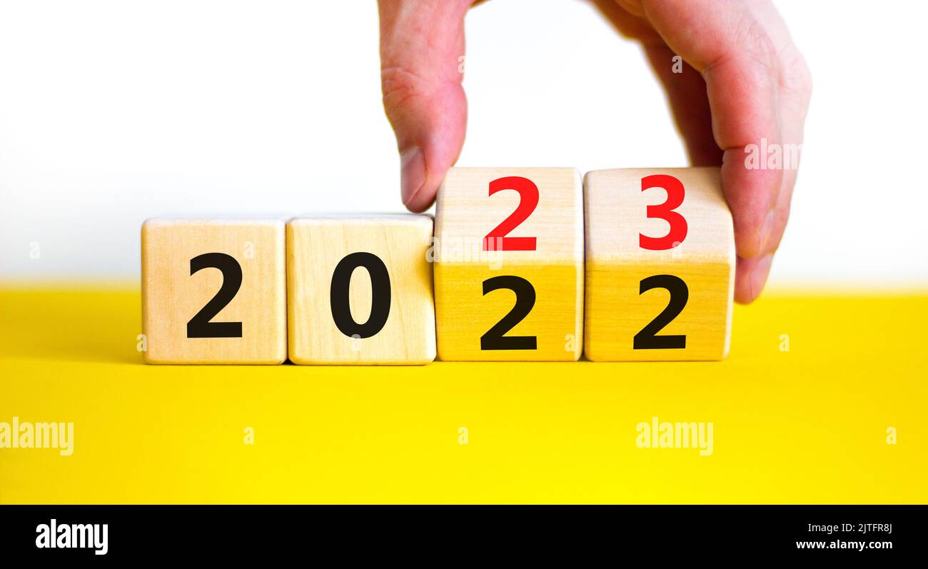 2023 happy new year symbol. Businessman turns cubes, symbolize the ...