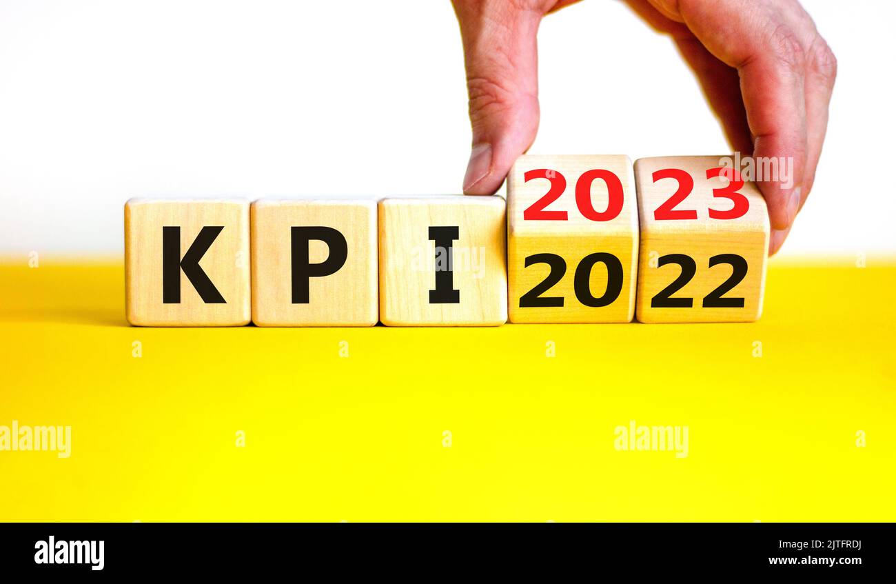 KPI, key performance indicator symbol. Businessman turns wooden cubes ...