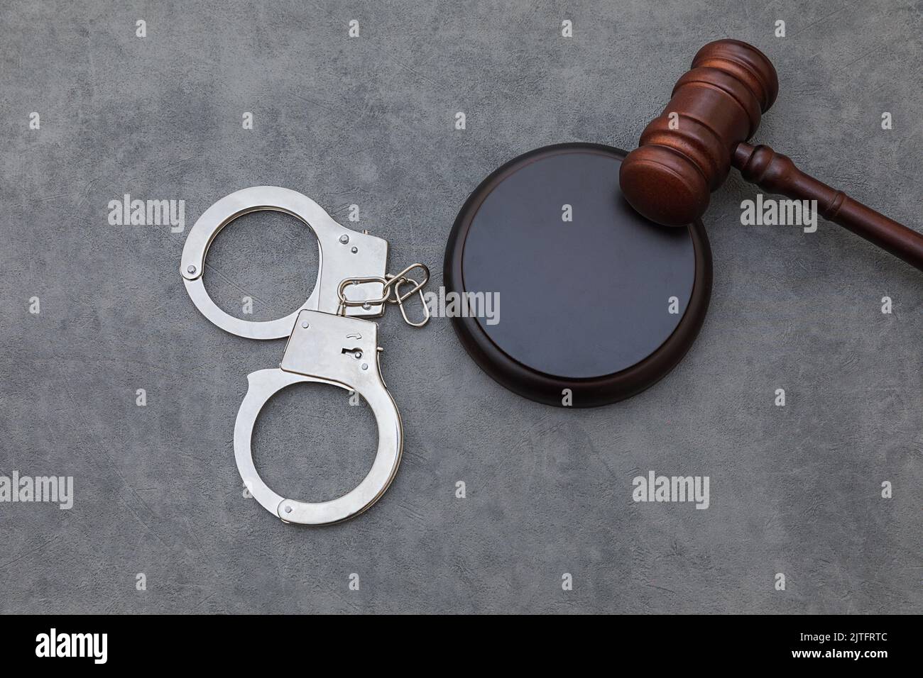 Law theme. Court of law trial in session. Judge gavel handcuffs on grey ...
