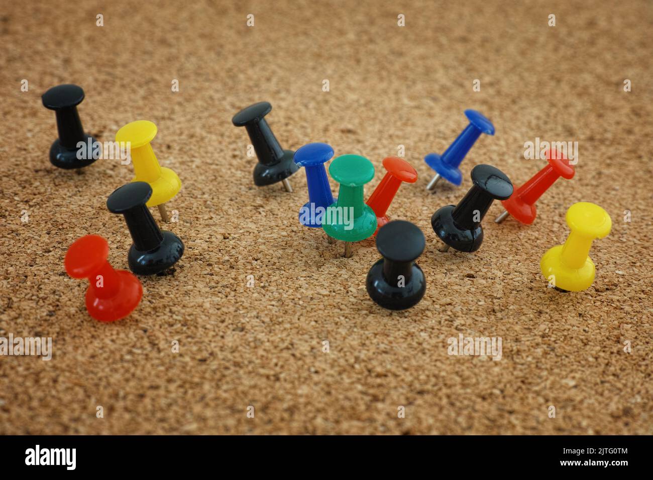 Colorful tacks attached to a corkboard. Close up Stock Photo - Alamy