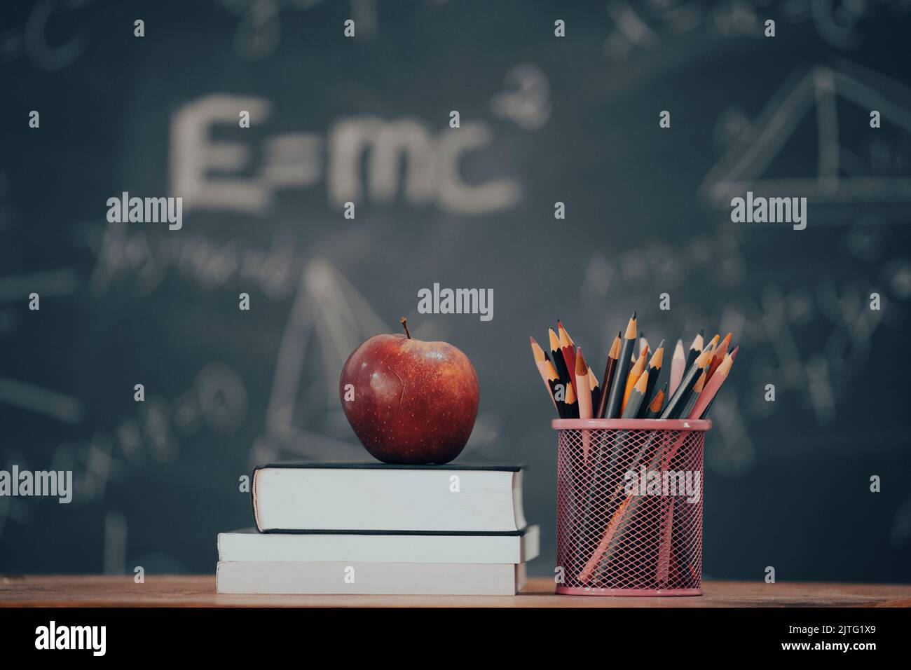 Back to School Concept. Apple, accessories and books against chalkboard ...
