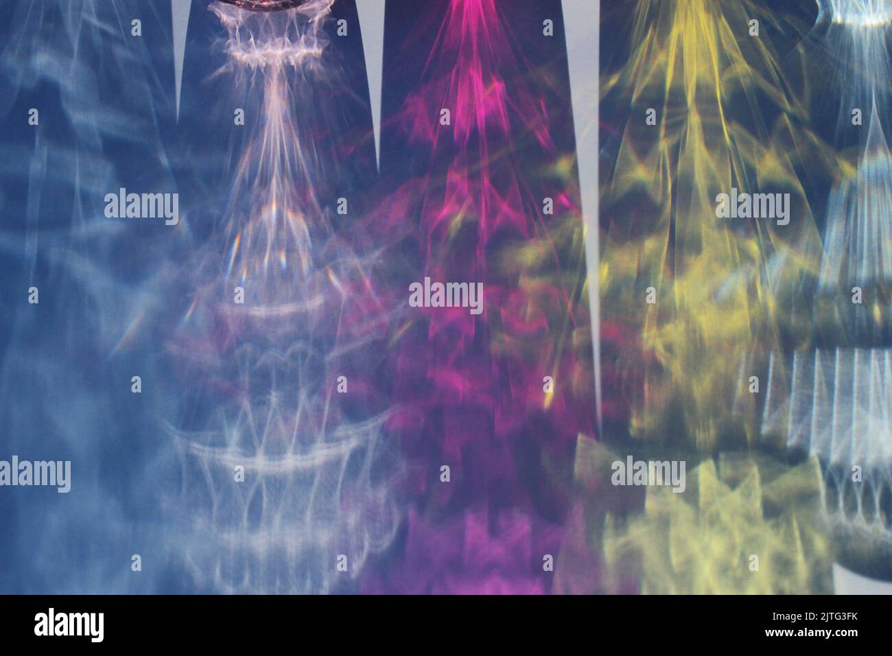 Sunlight through colored glass of water on blue background. Long harsh ...