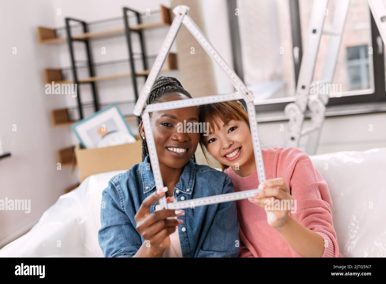 happy smiling women with ruler in shape of house Stock Photo - Alamy