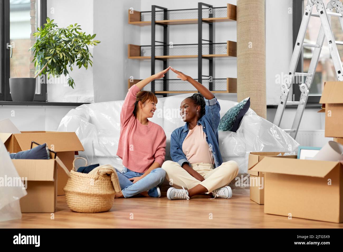 women with boxes moving to new home Stock Photo - Alamy