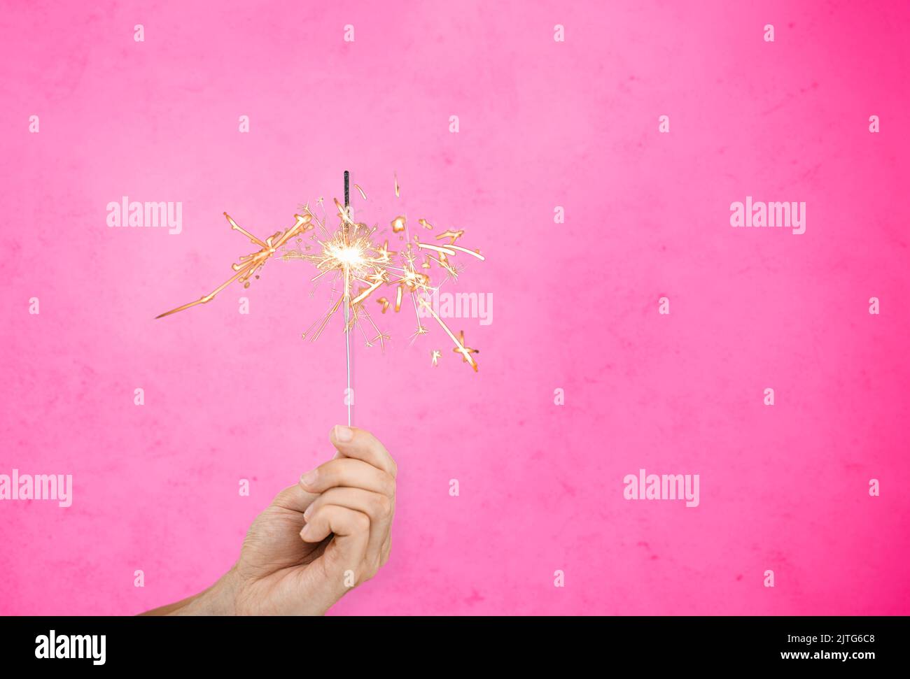 hand with sparkler burning over pink background Stock Photo - Alamy