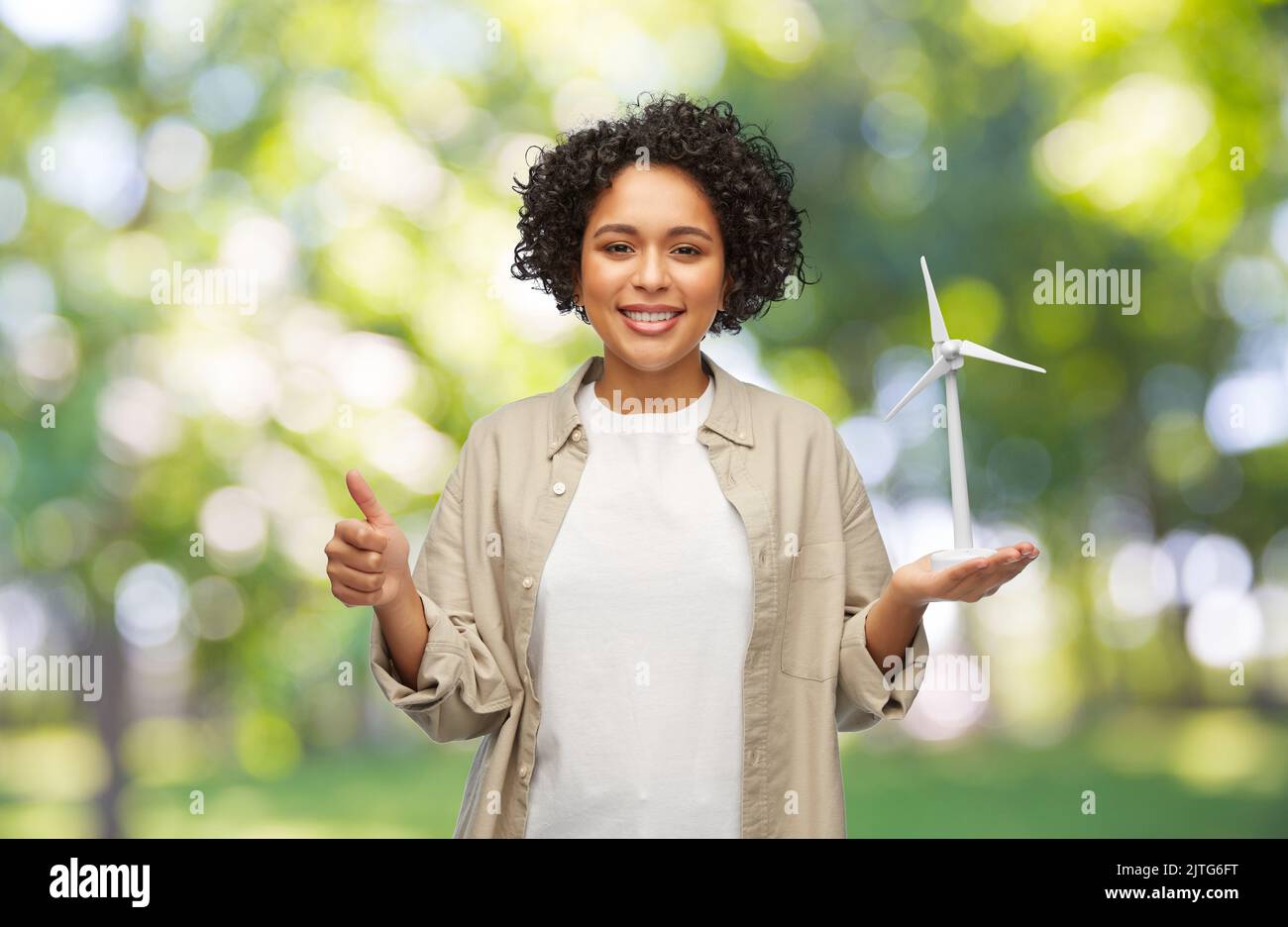 woman holding toy wind turbine showing thumbs up Stock Photo - Alamy