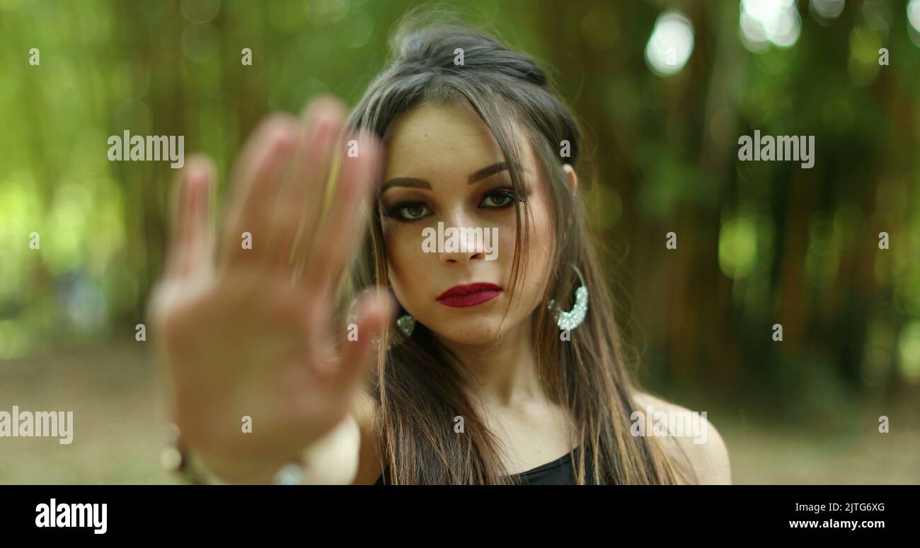 Serious defensive girl holding her hand in objection, saying NO. Young ...