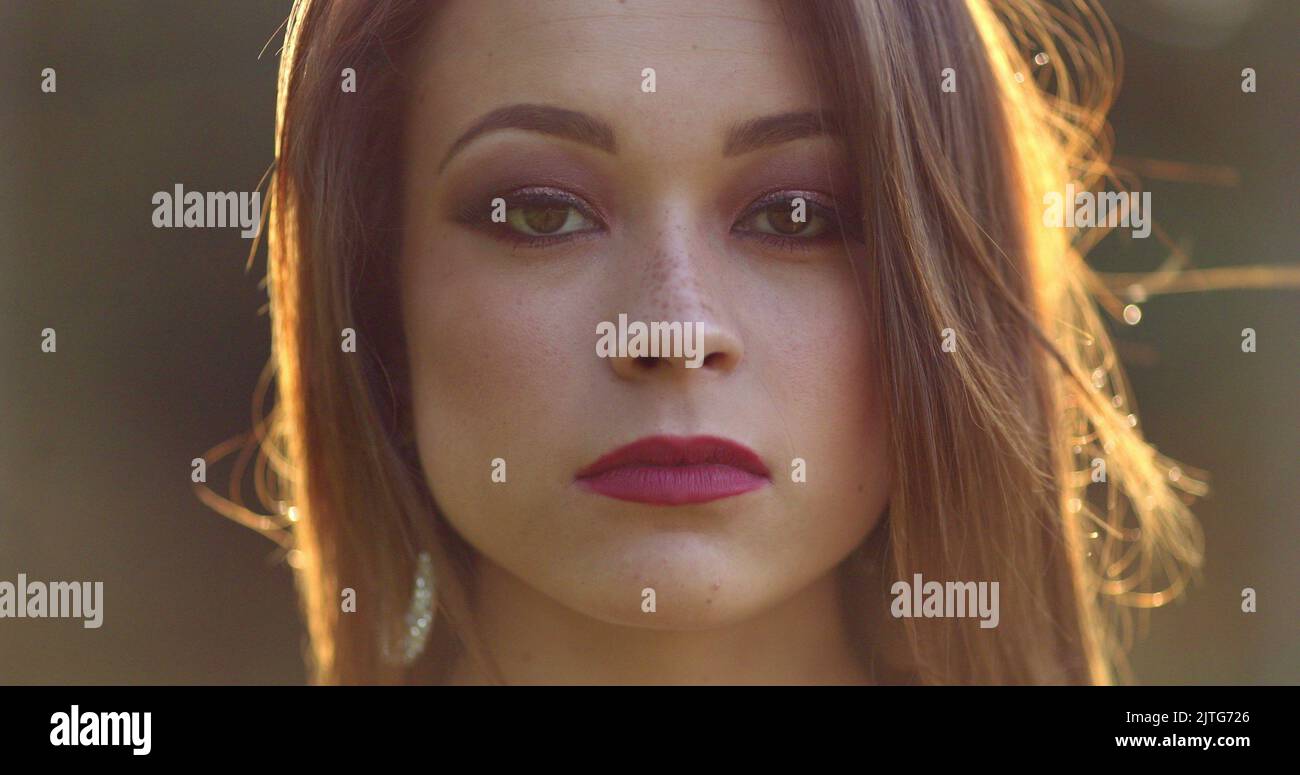 Serious pretty millennial girl looking directly to camera. Portrait ...