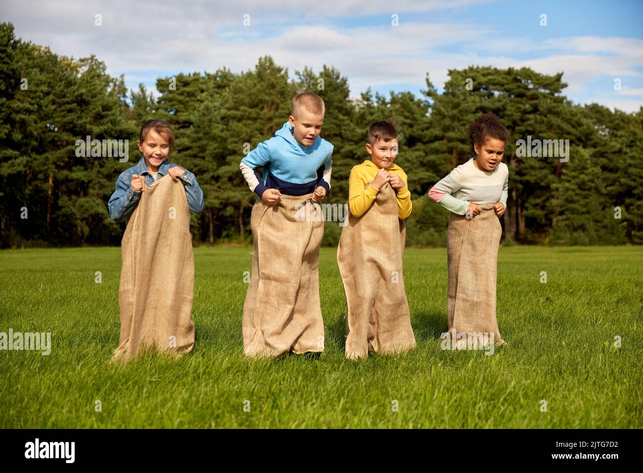 happy children playing bag jumping game at park Stock Photo - Alamy