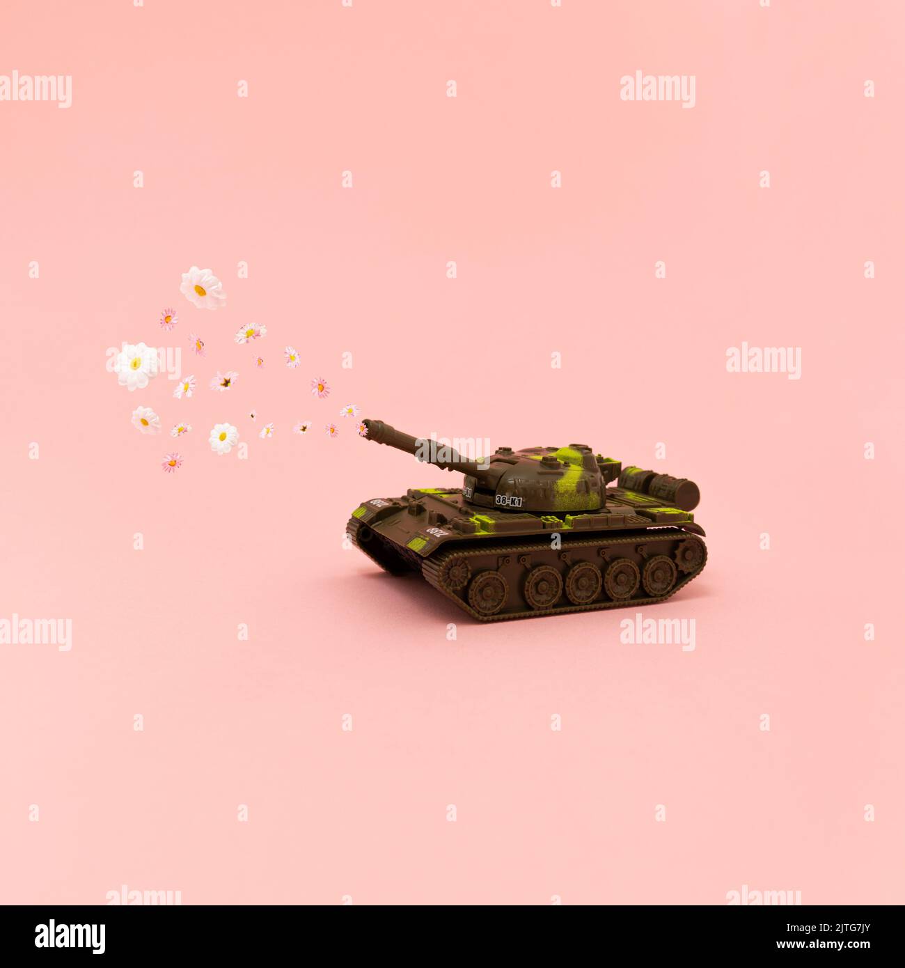A Small Military Camouflaged Tank That Shoots Multi Colored Flowers On A Pink Light Background