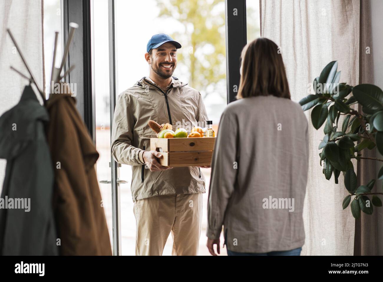 food delivery man giving order to female customer Stock Photo - Alamy