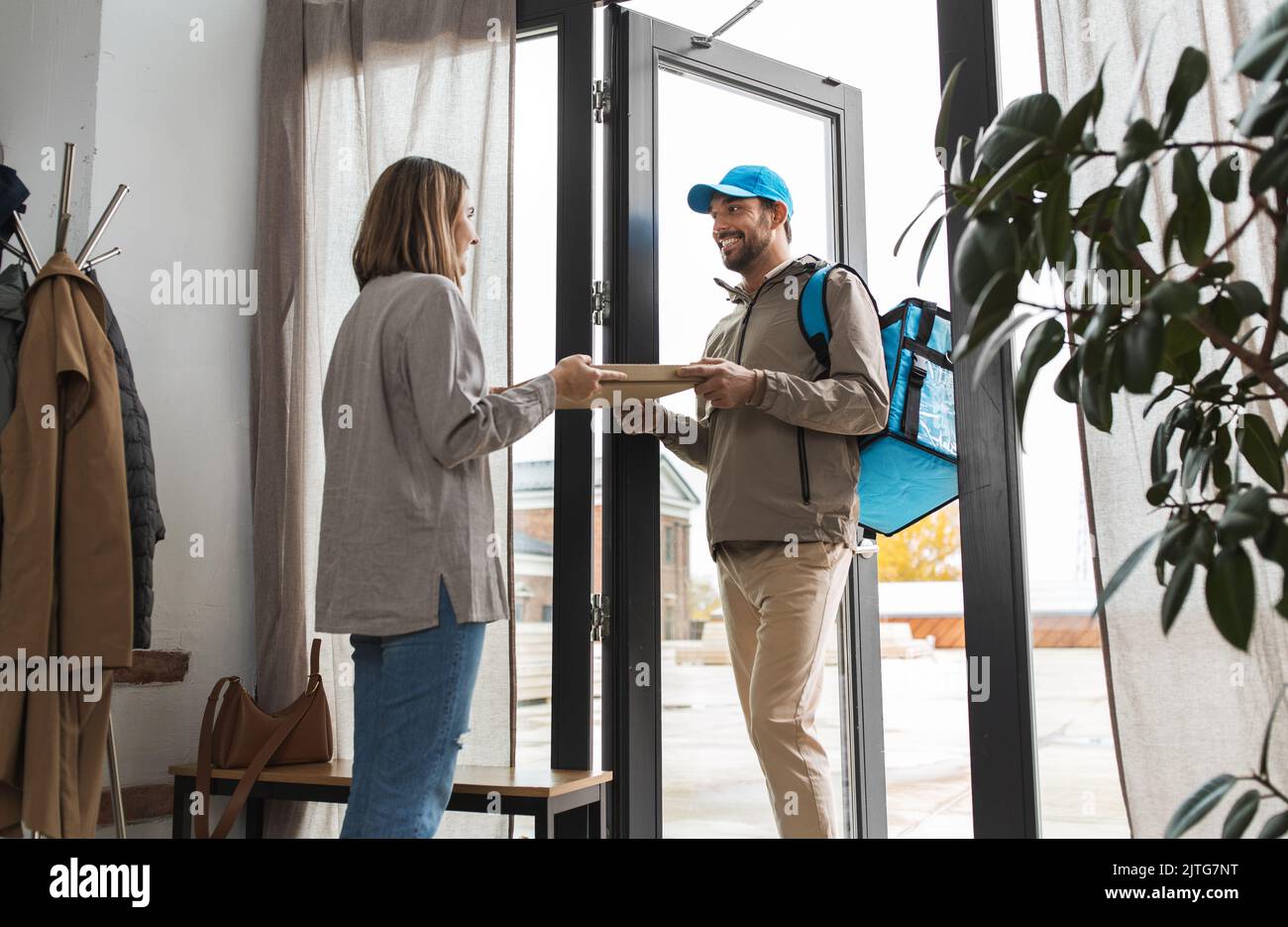 food delivery man giving order to female customer Stock Photo - Alamy