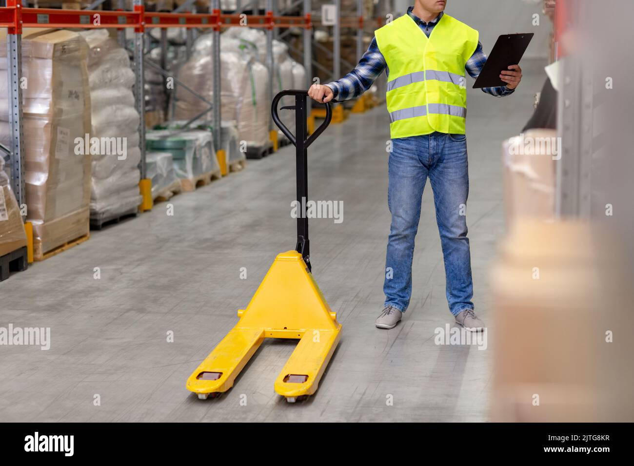 man with loader and clipboard at warehouse Stock Photo - Alamy