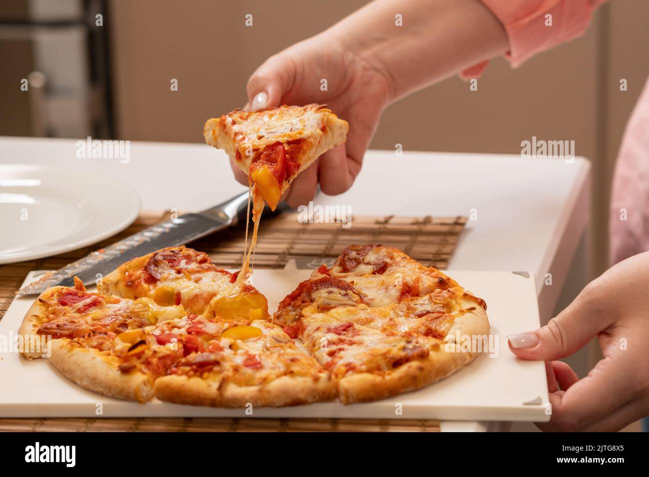 Raised slice of pizza before eating it and stretching strands of cheese ...