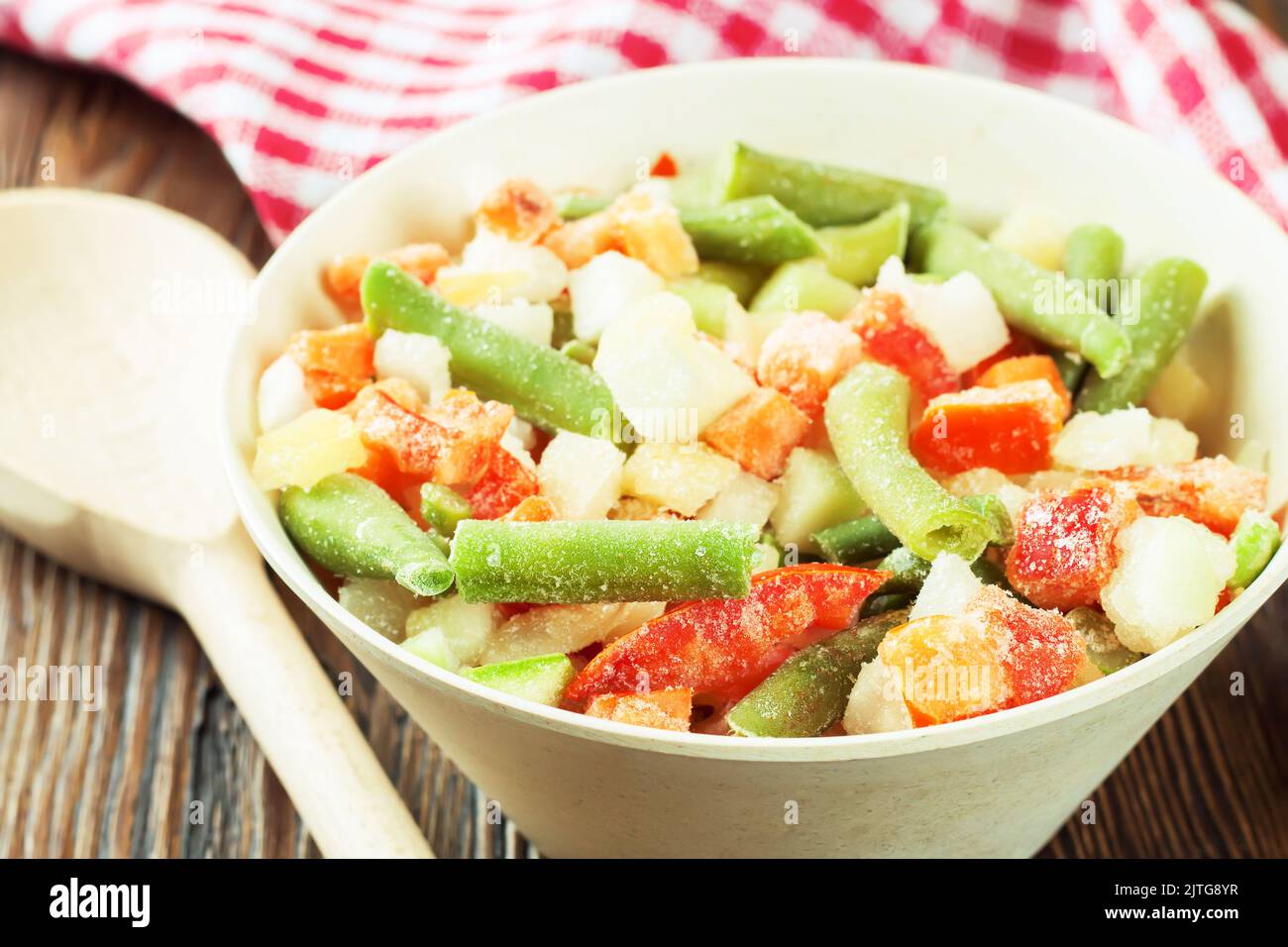 A mixture of assorted frozen vegetables in white bowl ready for cooking ...