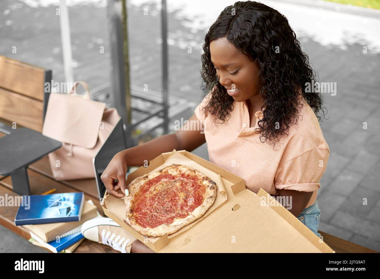 african student girl eating takeaway pizza in city Stock Photo - Alamy