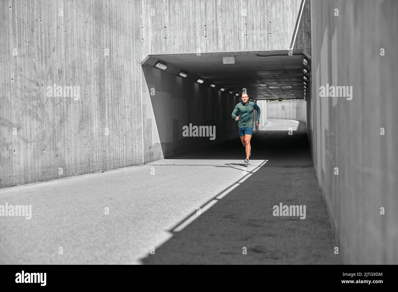 young man running out of tunnel Stock Photo - Alamy