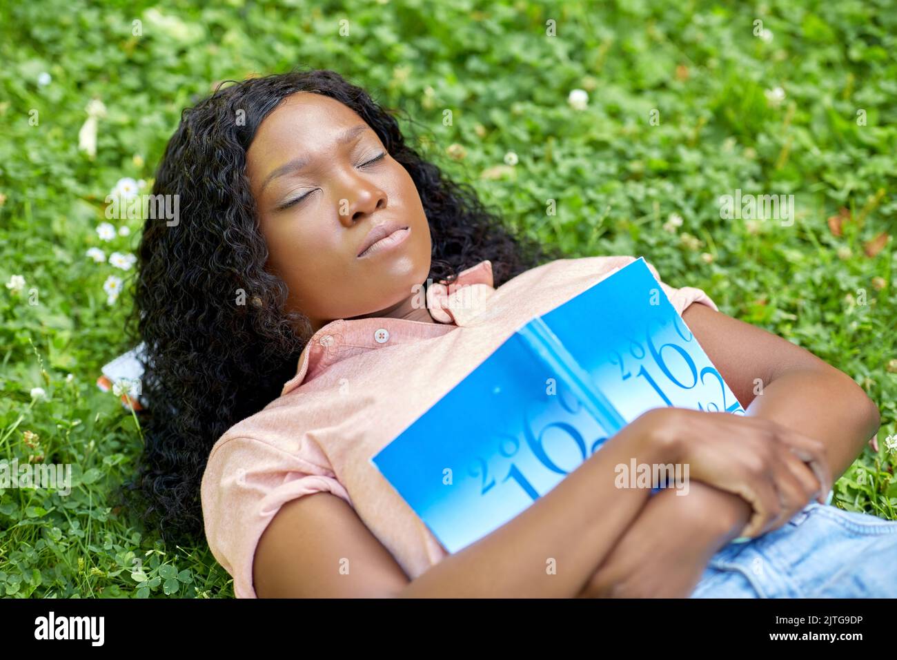 Girl sleeping on grass hi-res stock photography and images - Alamy