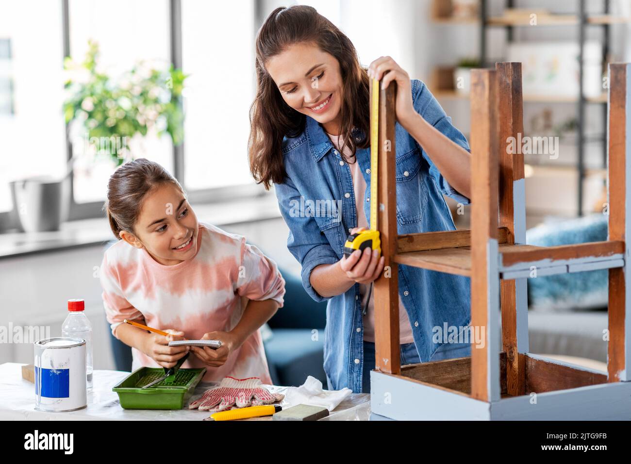 mother and daughter with ruler measuring old table Stock Photo - Alamy