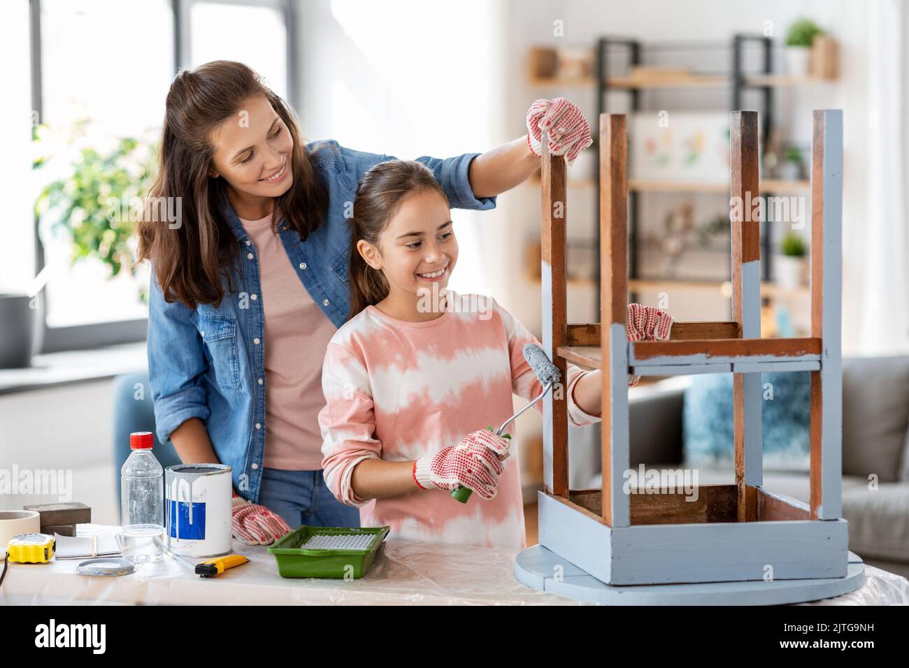 mother and daughter painting old table in grey Stock Photo - Alamy