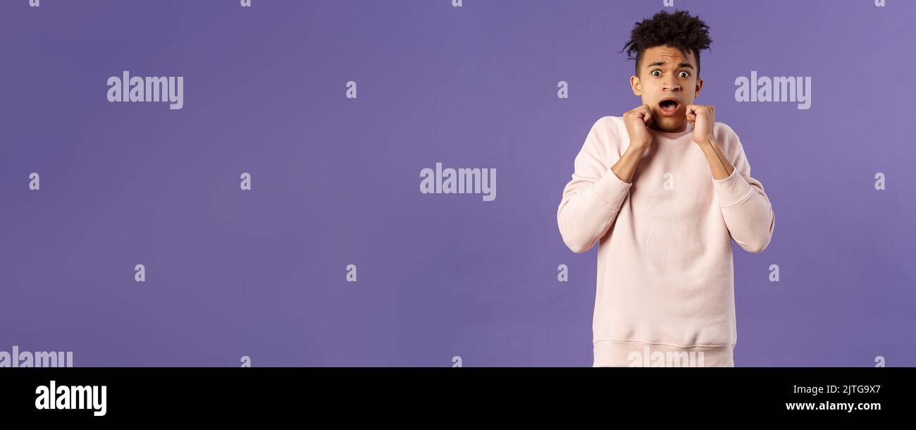 Portrait of scared hispanic guy screaming from fright, hold hands near ...