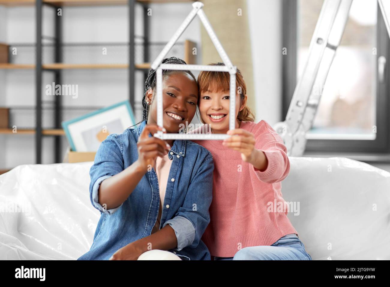 happy smiling women with ruler in shape of house Stock Photo - Alamy