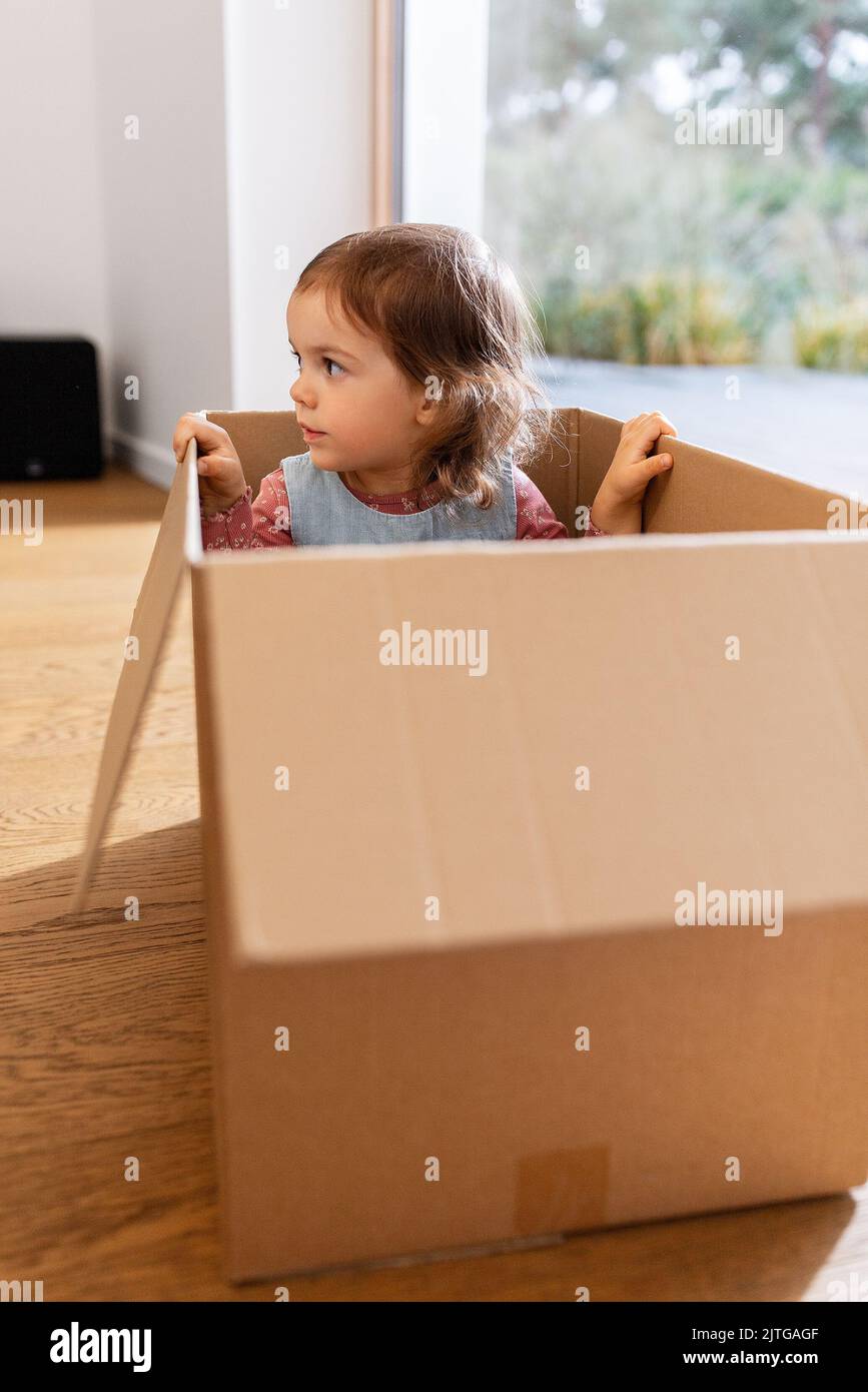 little baby girl sitting in cardboard box at home Stock Photo - Alamy