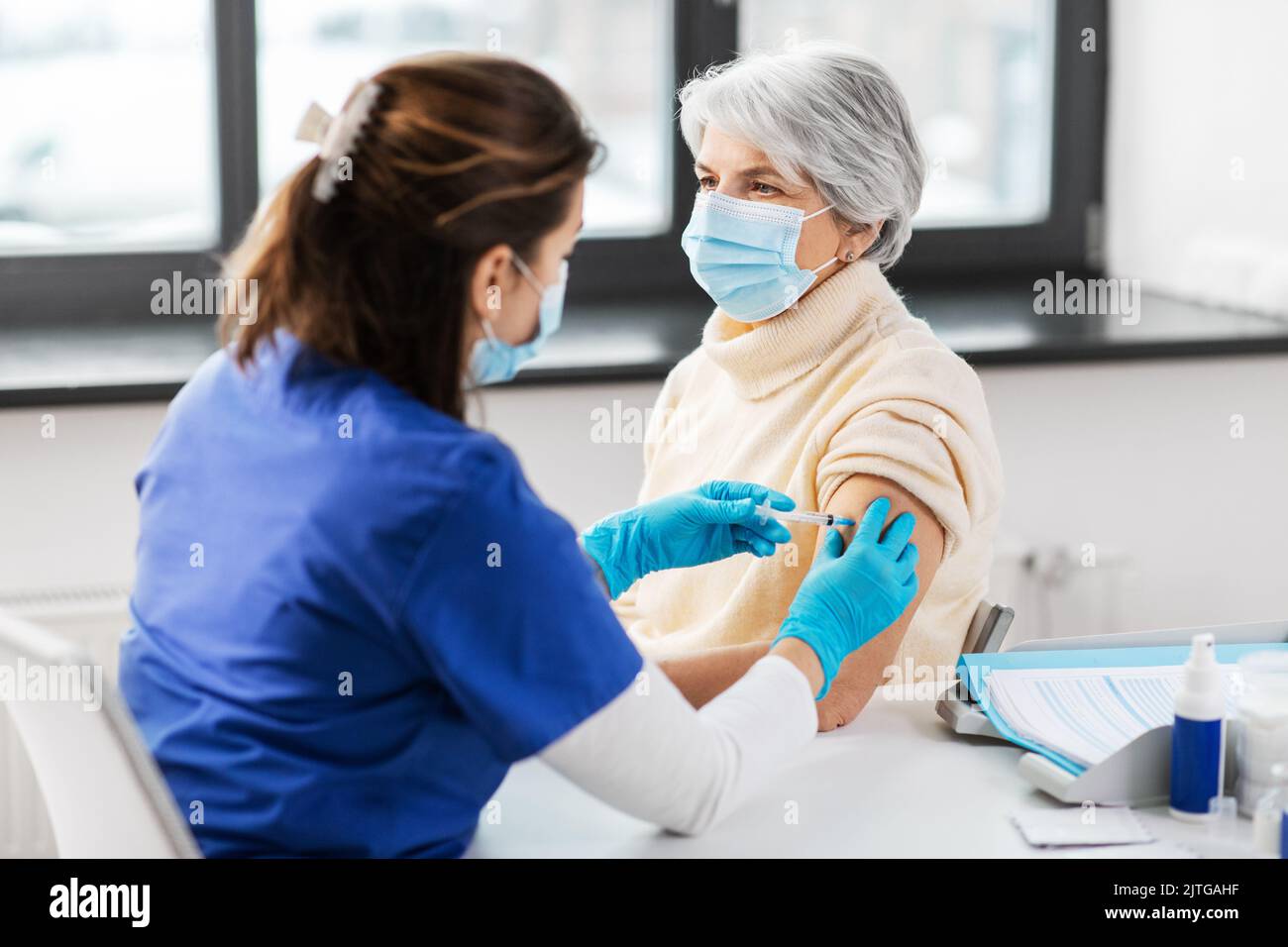 nurse with syringe making injection to woman Stock Photo - Alamy