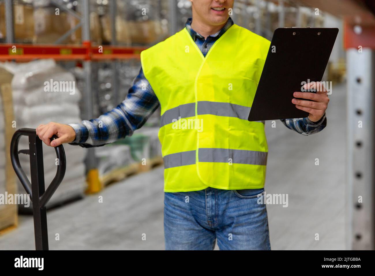 man with loader and clipboard at warehouse Stock Photo - Alamy