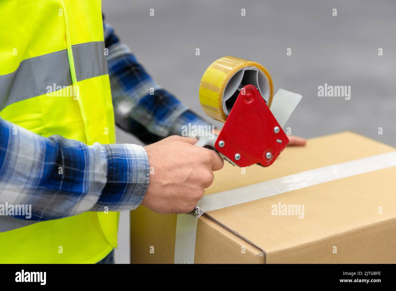 warehouse worker packing parcel with scotch tape Stock Photo - Alamy