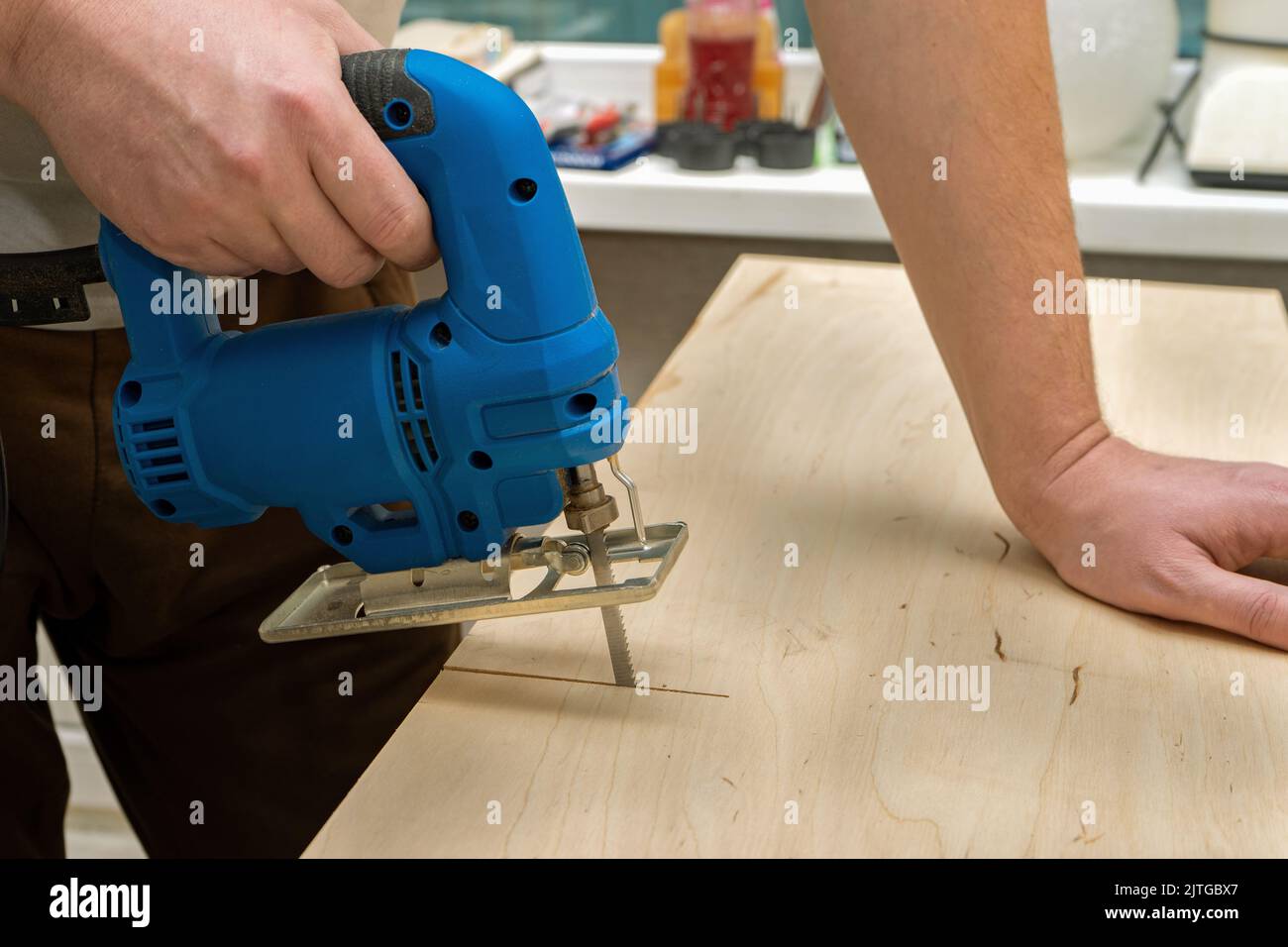 Image of a man hand using electric jigsaw. close up process of cutting ...