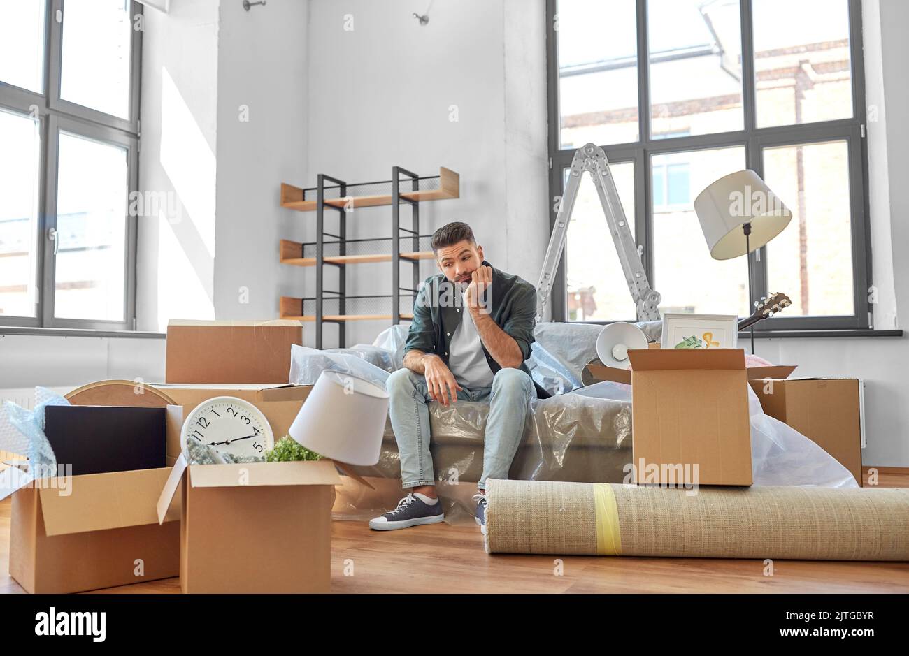 sad man with boxes moving to new home Stock Photo - Alamy