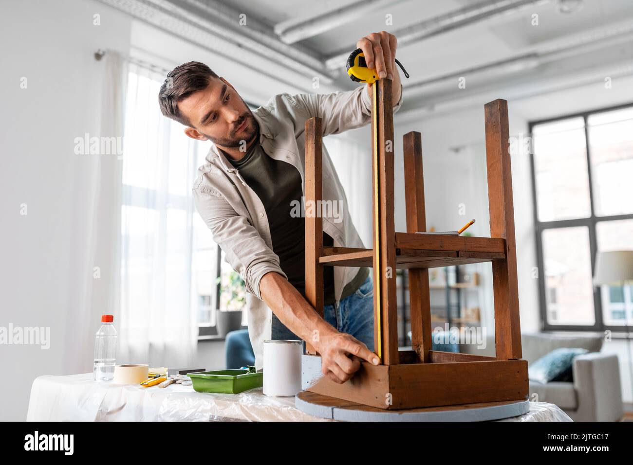 man with ruler measuring table for renovation Stock Photo - Alamy