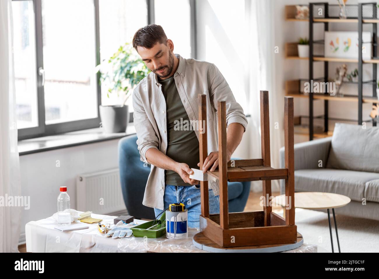 man sticking adhesive tape to table for repainting Stock Photo - Alamy